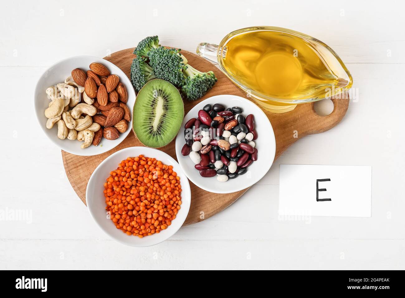 Board with healthy products rich in vitamin E on light wooden ...