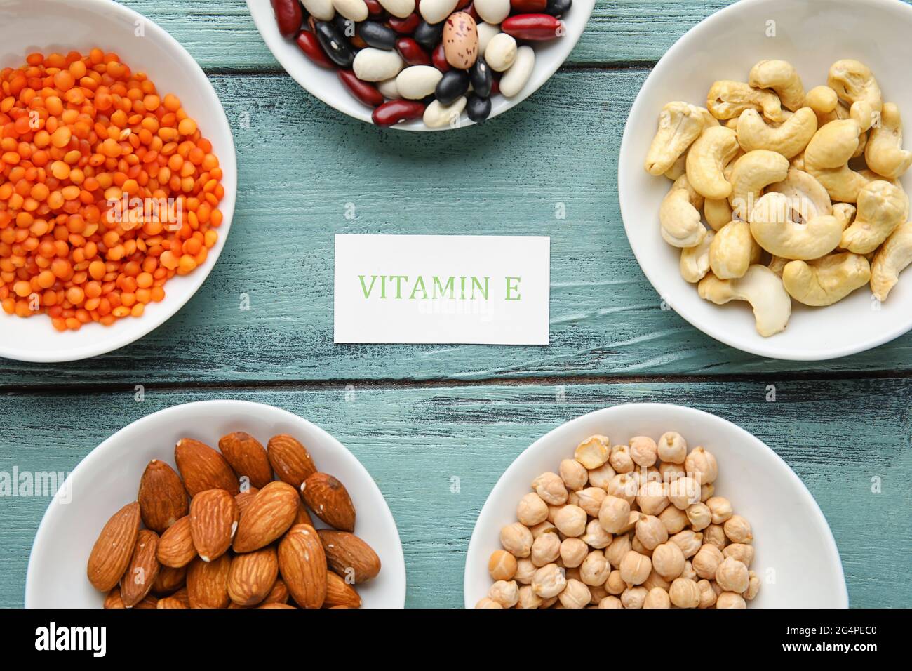 Plates with different healthy nuts and beans rich in vitamin E on color ...