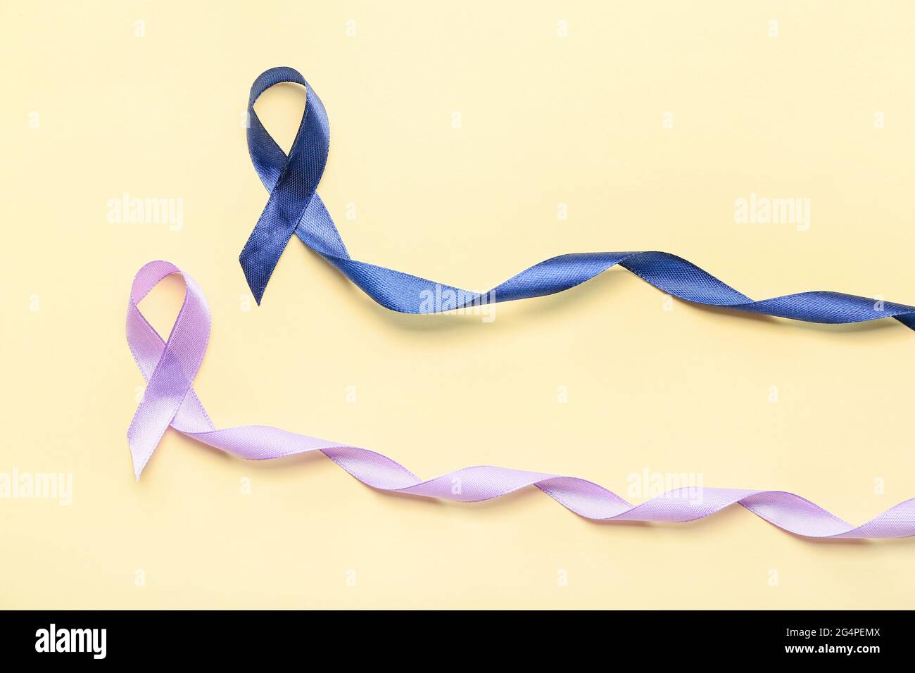 Lilac and blue ribbons on color background. Cancer awareness concept ...
