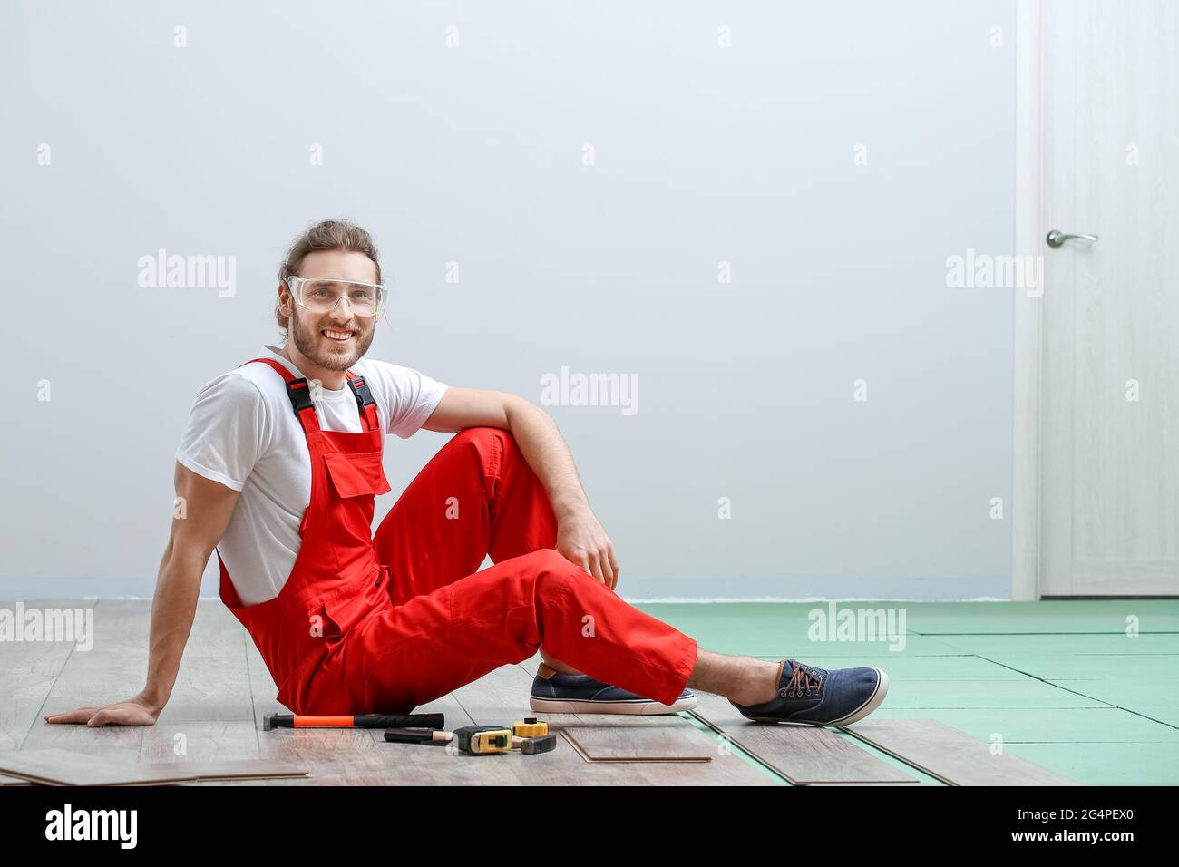 Carpenter during installing of laminate flooring in room Stock Photo ...