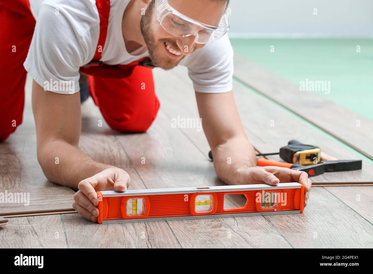 Carpenter taking measurements of laminate flooring in room Stock Photo ...