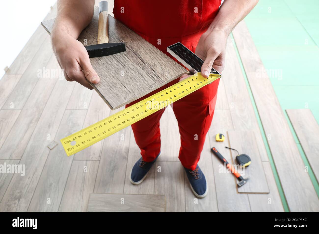 Carpenter taking measurements of laminate flooring in room Stock Photo ...