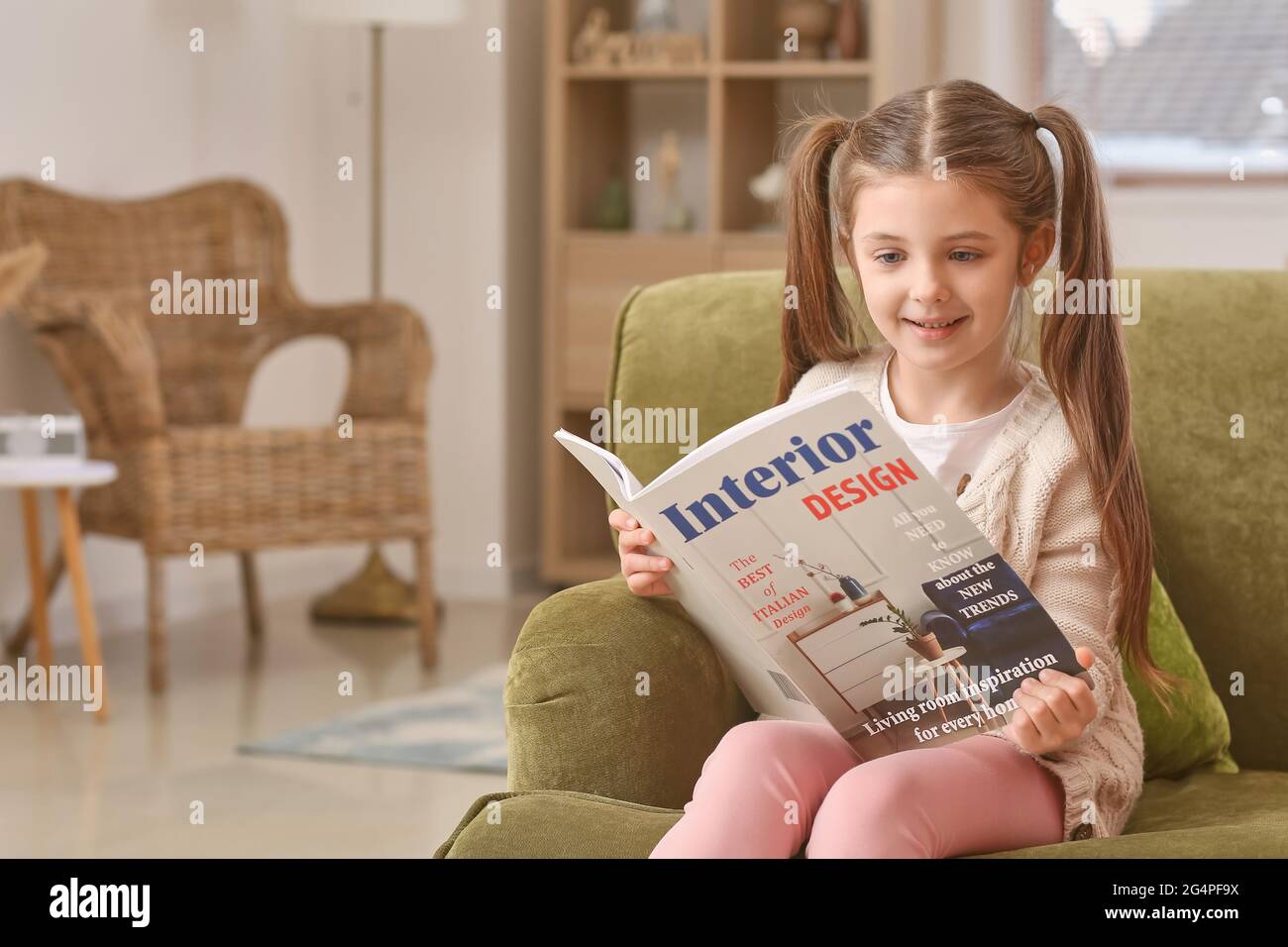 Little girl reading magazine at home Stock Photo - Alamy