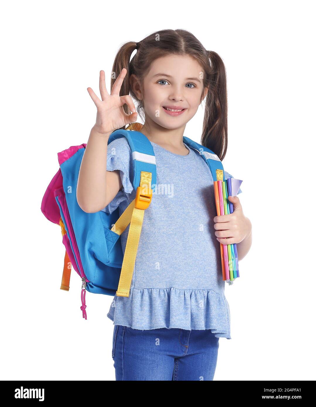 Little girl with backpack showing OK on white background Stock Photo ...