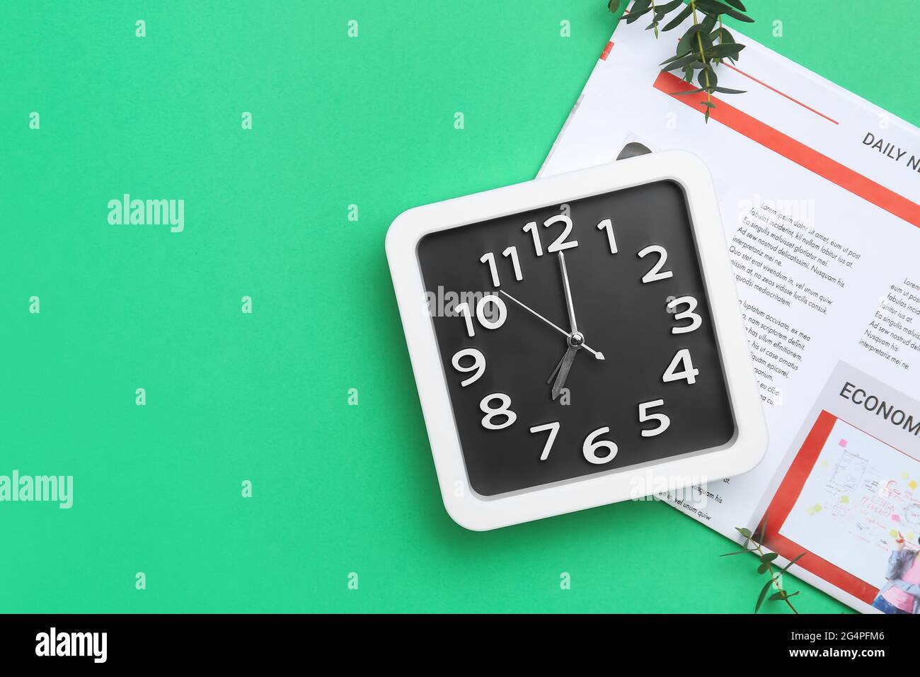 Stylish clock and newspaper on color background Stock Photo - Alamy