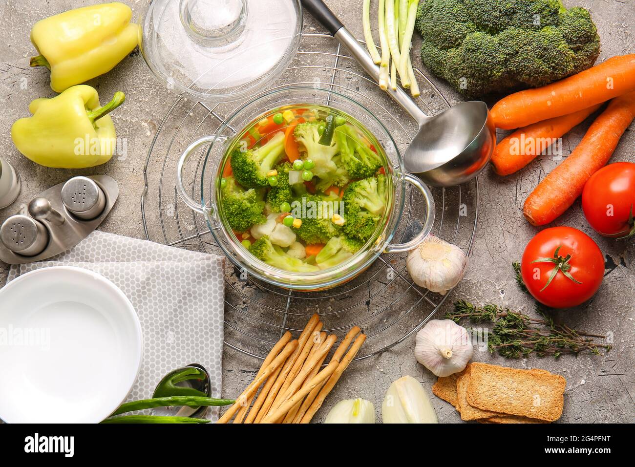 Stylish cooking pot with tasty soup and ingredients on grunge ...