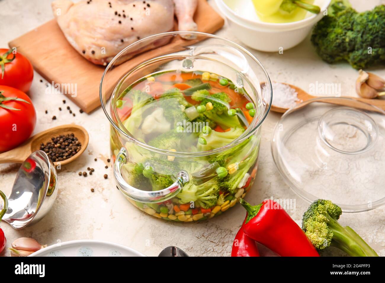 Stylish cooking pot with tasty soup and ingredients on light background ...