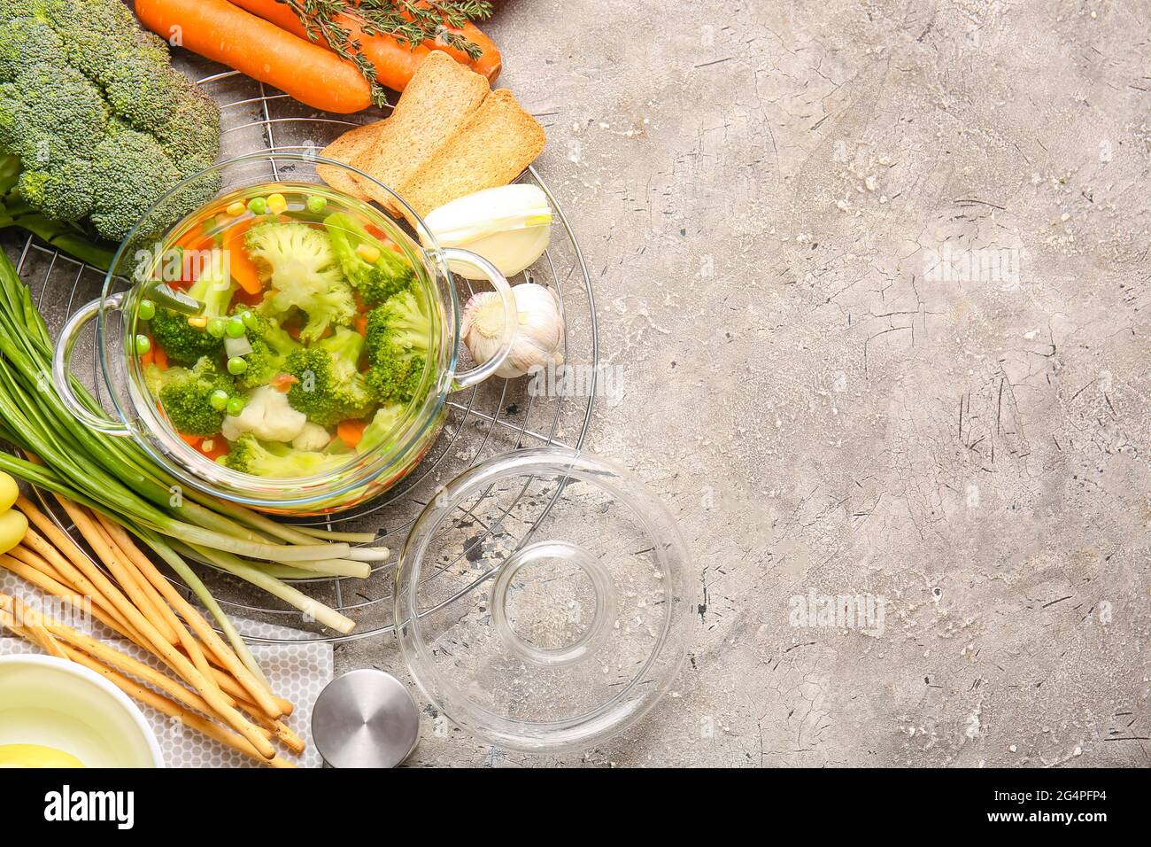 Stylish cooking pot with tasty soup and ingredients on grunge ...