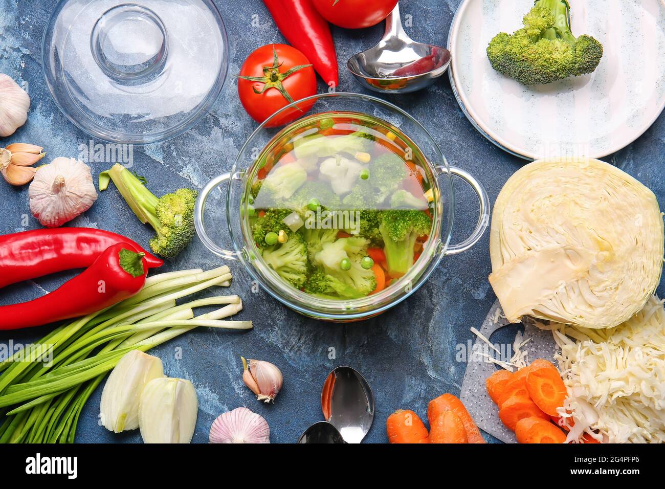 Stylish cooking pot with tasty soup and ingredients on color background ...
