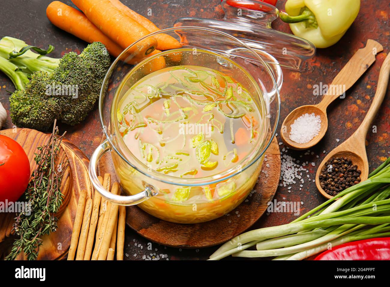 Stylish cooking pot with tasty soup and ingredients on grunge ...