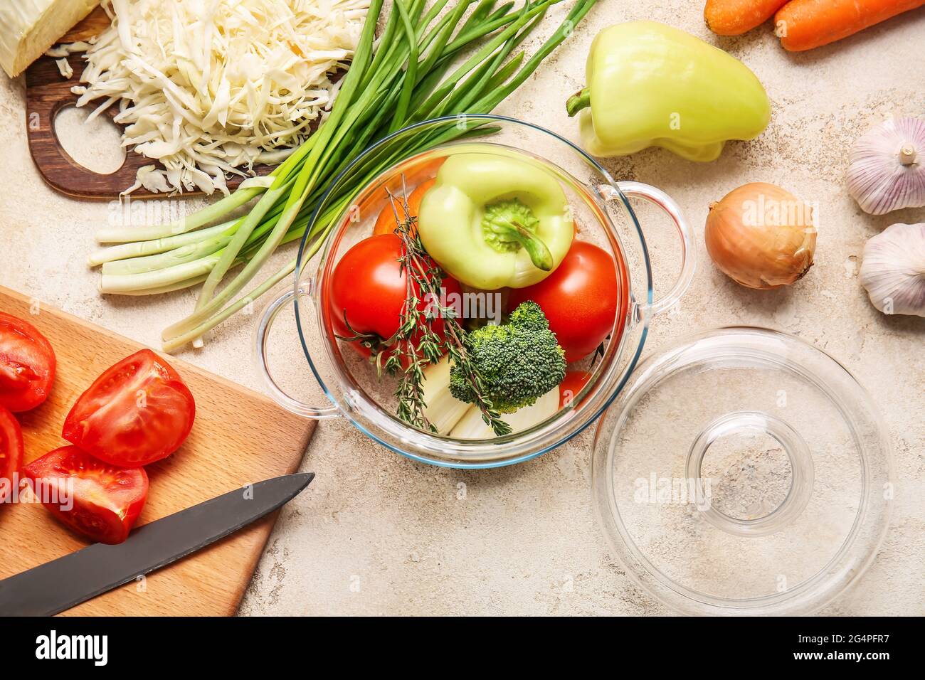 Stylish cooking pot with fresh vegetables on light background Stock ...