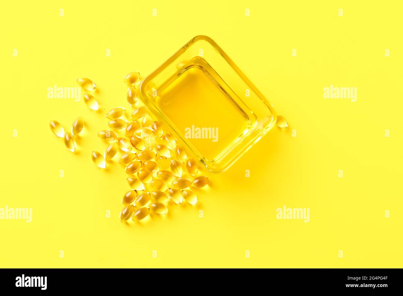 Bowl of fish oil and capsules on color background Stock Photo - Alamy
