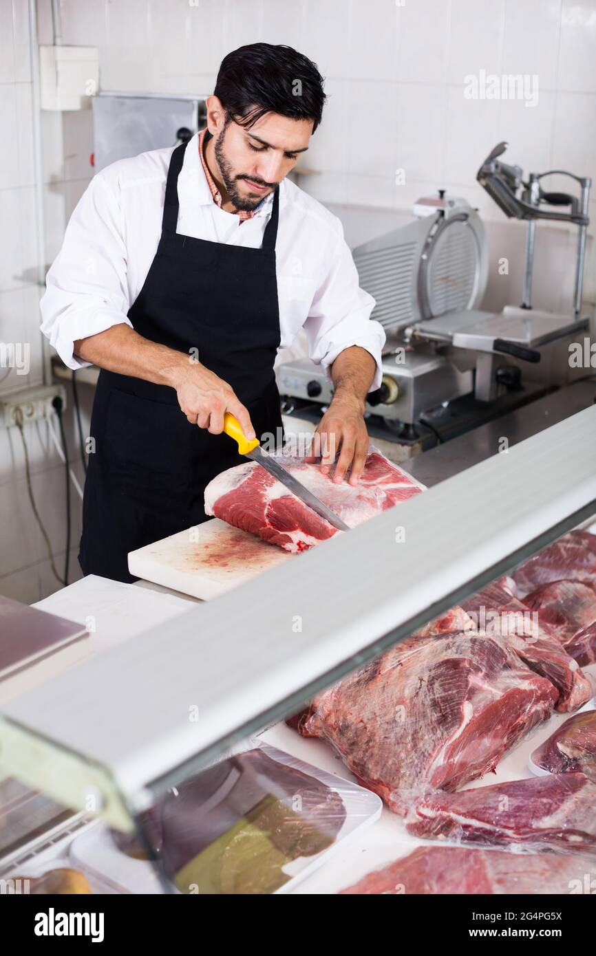 Man butcher is cutting meat on his workplace in the market Stock Photo ...