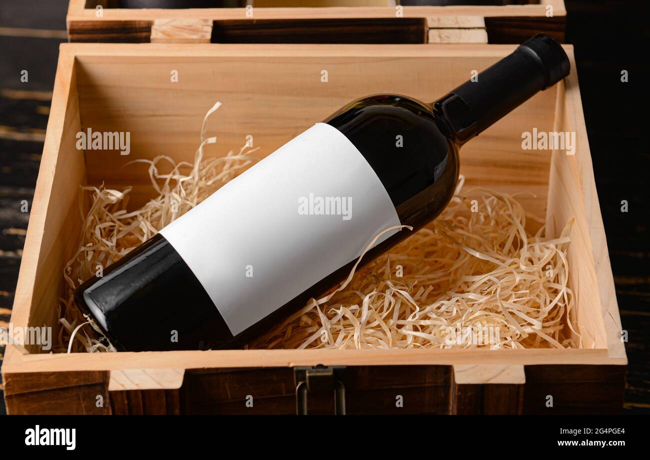Box with bottle of wine on dark background, closeup Stock Photo - Alamy