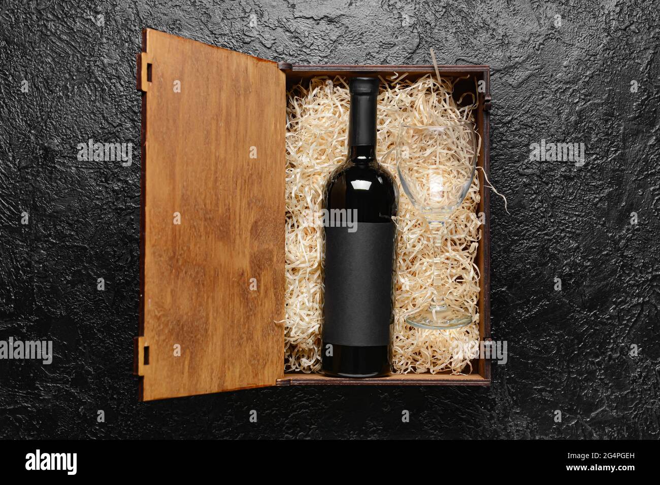 Box with bottle of wine on dark background Stock Photo - Alamy