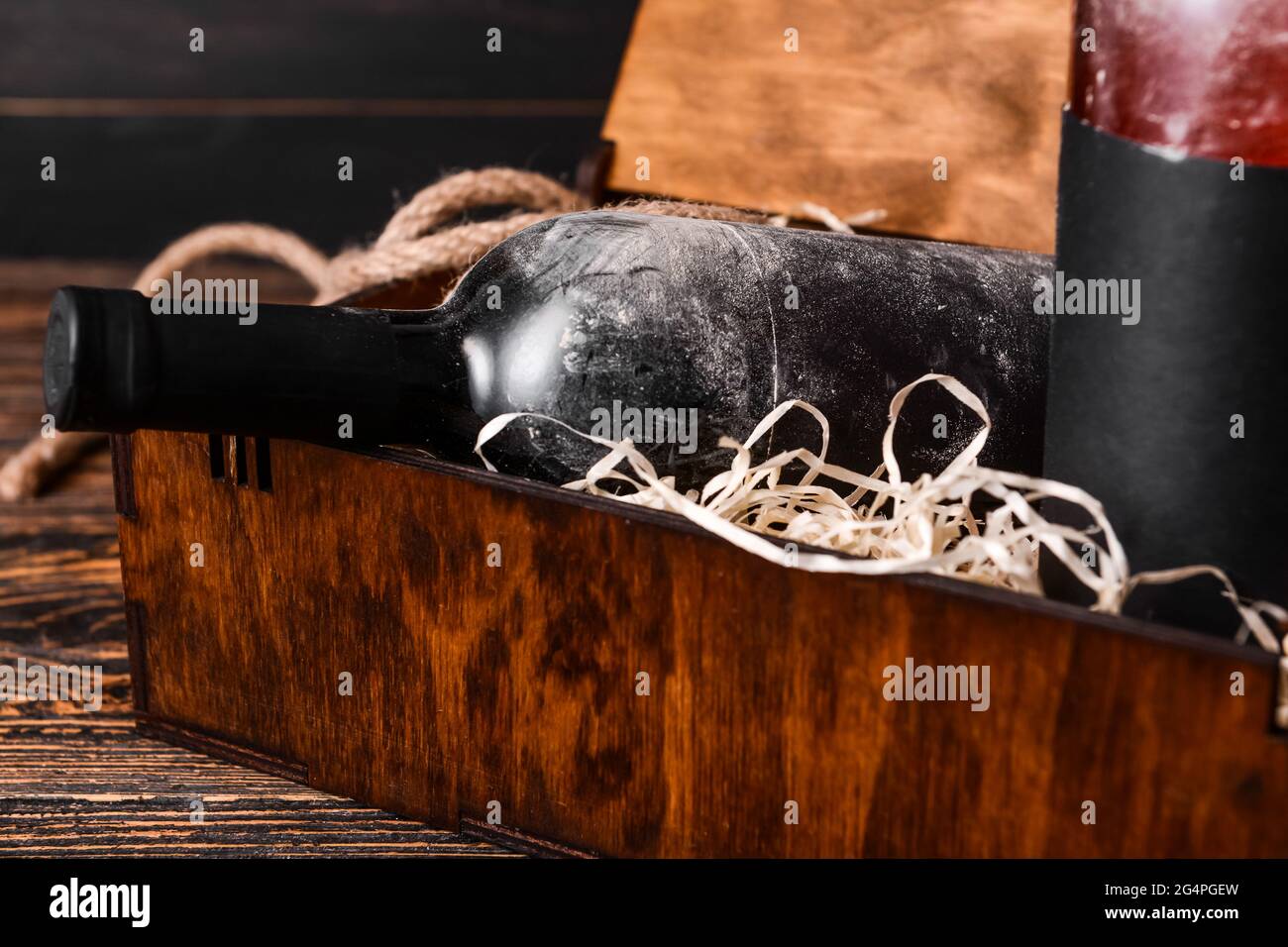 Box with bottles of wine on wooden background, closeup Stock Photo - Alamy