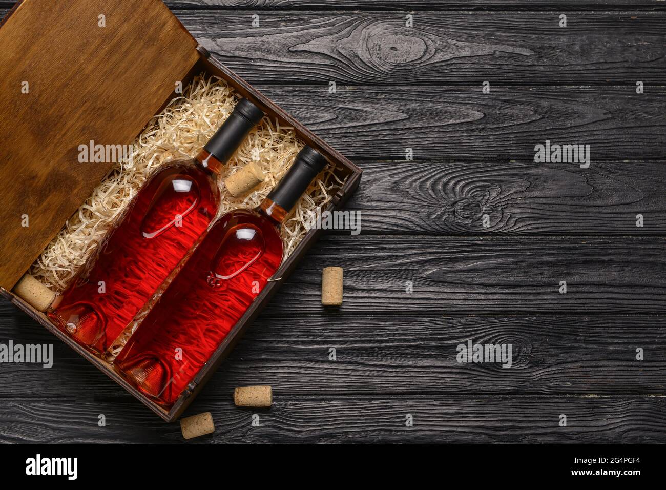 Box with bottles of wine on dark wooden background Stock Photo - Alamy