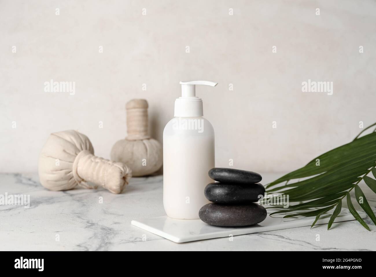 Spa stones with cosmetics on white background Stock Photo - Alamy