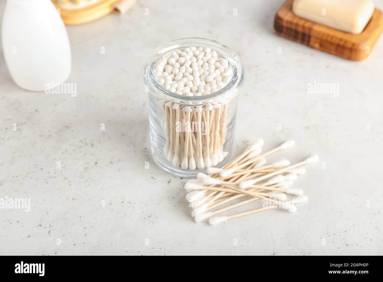 Glass with cotton swabs on light background Stock Photo - Alamy