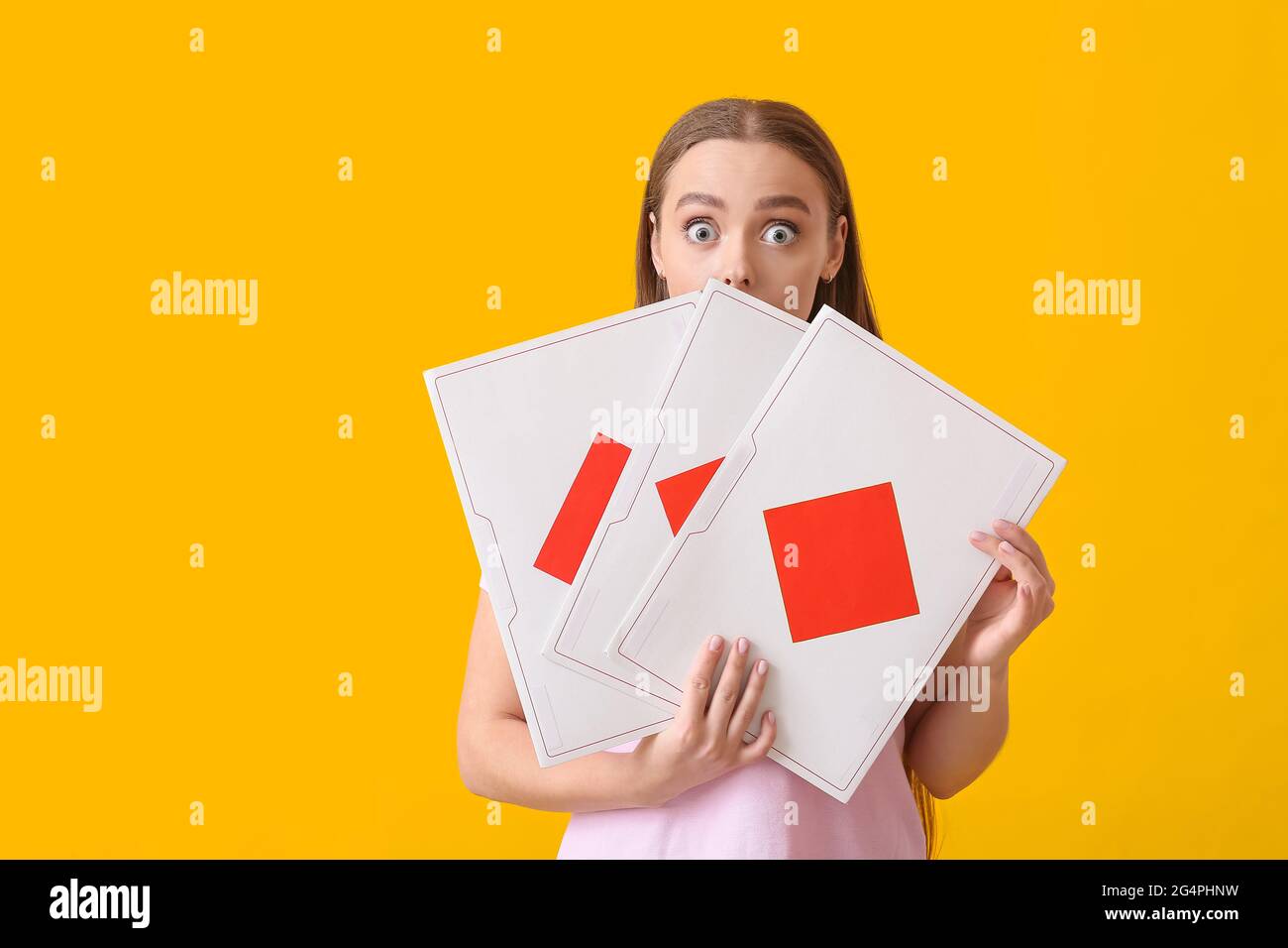 Shocked young woman with letters on color background Stock Photo - Alamy