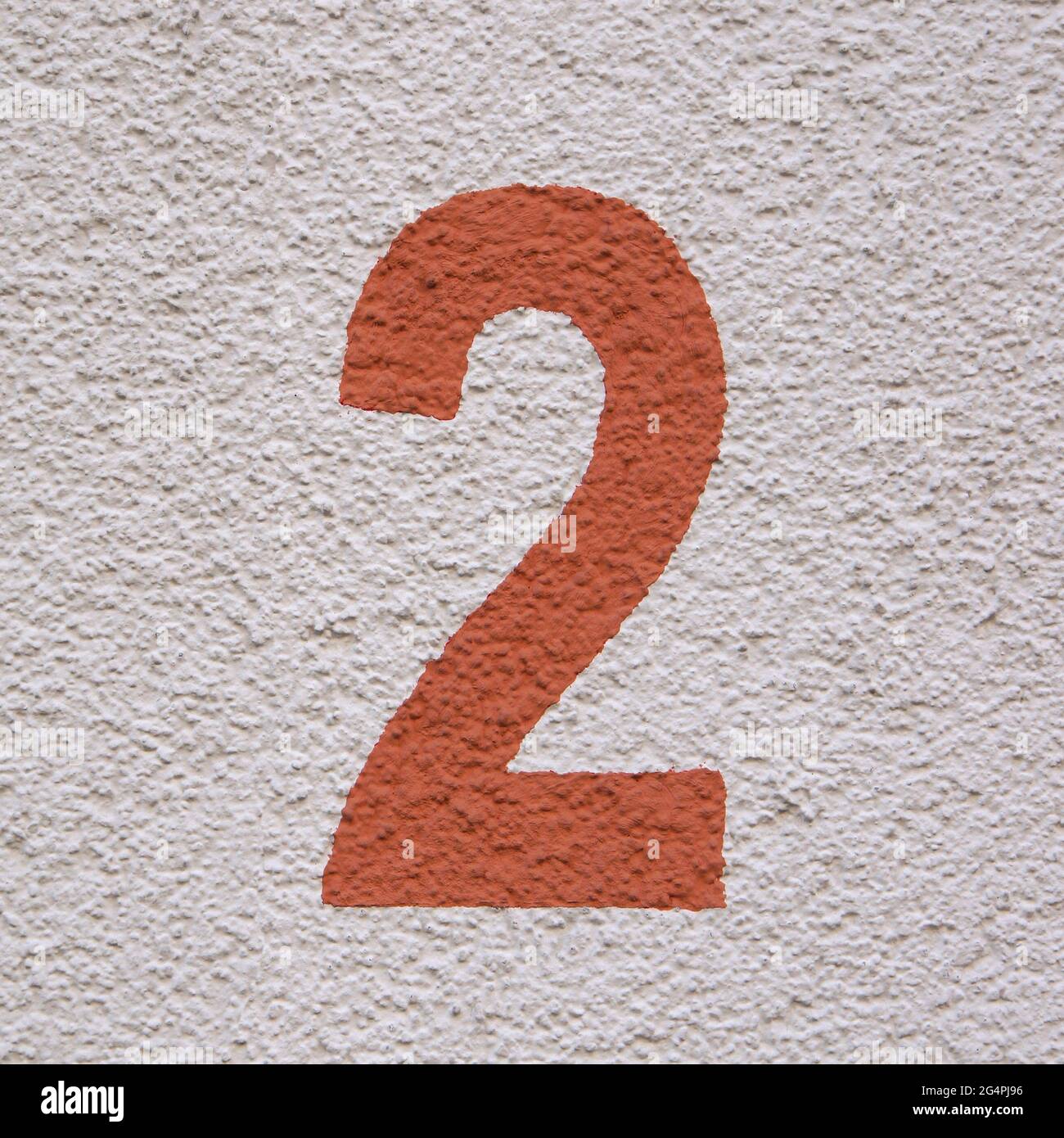 Closeup of red-colored number 2 on white concrete wall background Stock ...