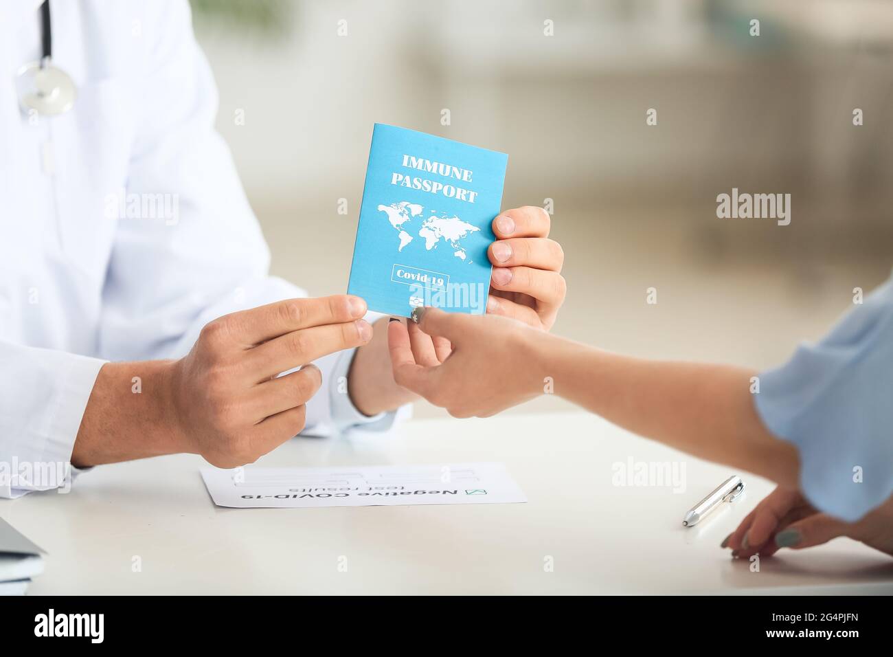 Doctor giving patient her immune passport in clinic Stock Photo - Alamy