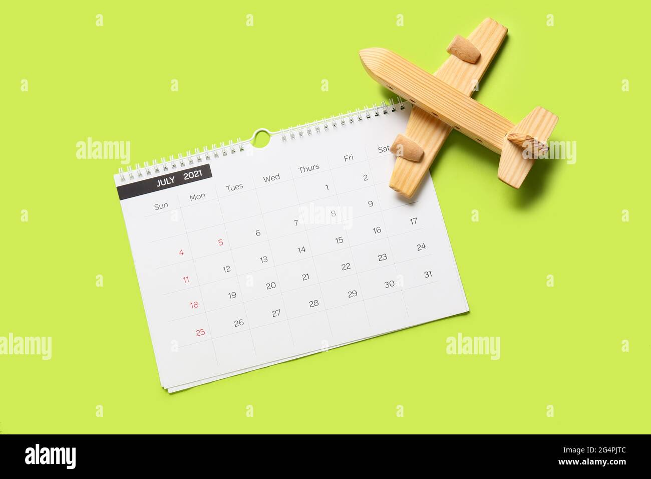Calendar and wooden airplane on color background Stock Photo - Alamy
