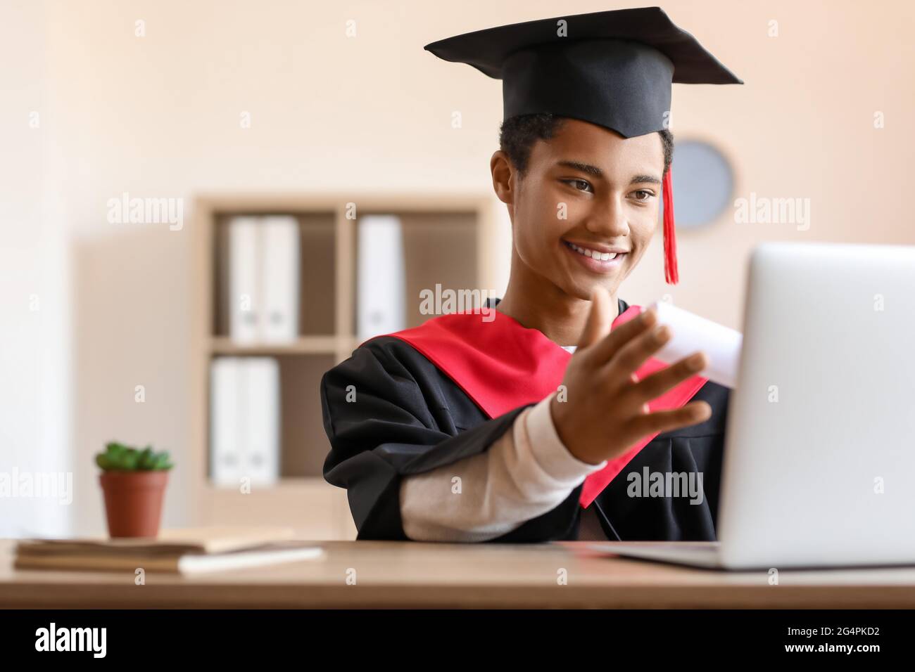 Happy African-American student on his graduation day at home. Concept ...