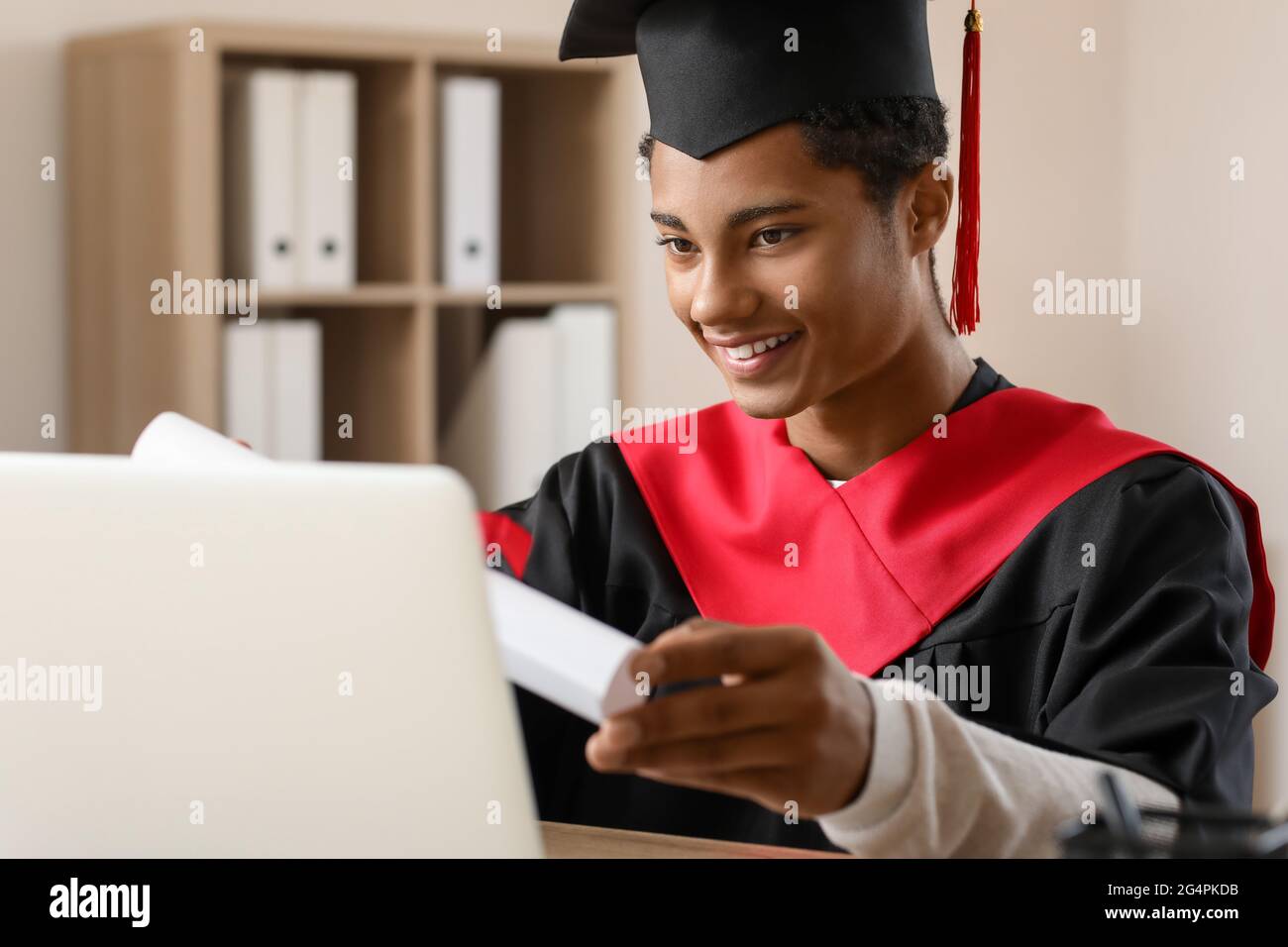 Happy African-American student on his graduation day at home. Concept ...