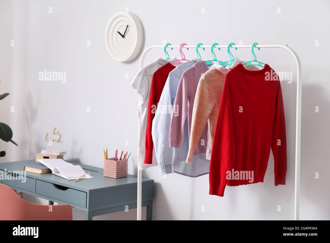 Rack with stylish school uniform in interior of room Stock Photo - Alamy