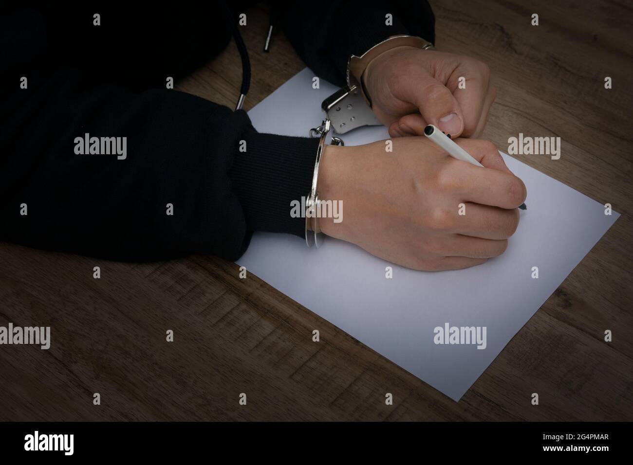 handcuffed criminal filling in statement, papers Stock Photo - Alamy