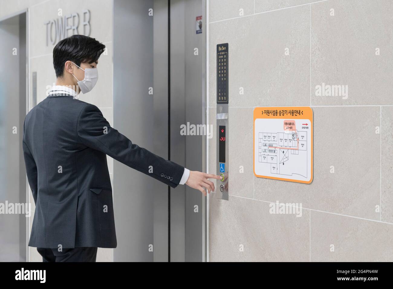 Asian man employee with mask riding elevator Stock Photo - Alamy