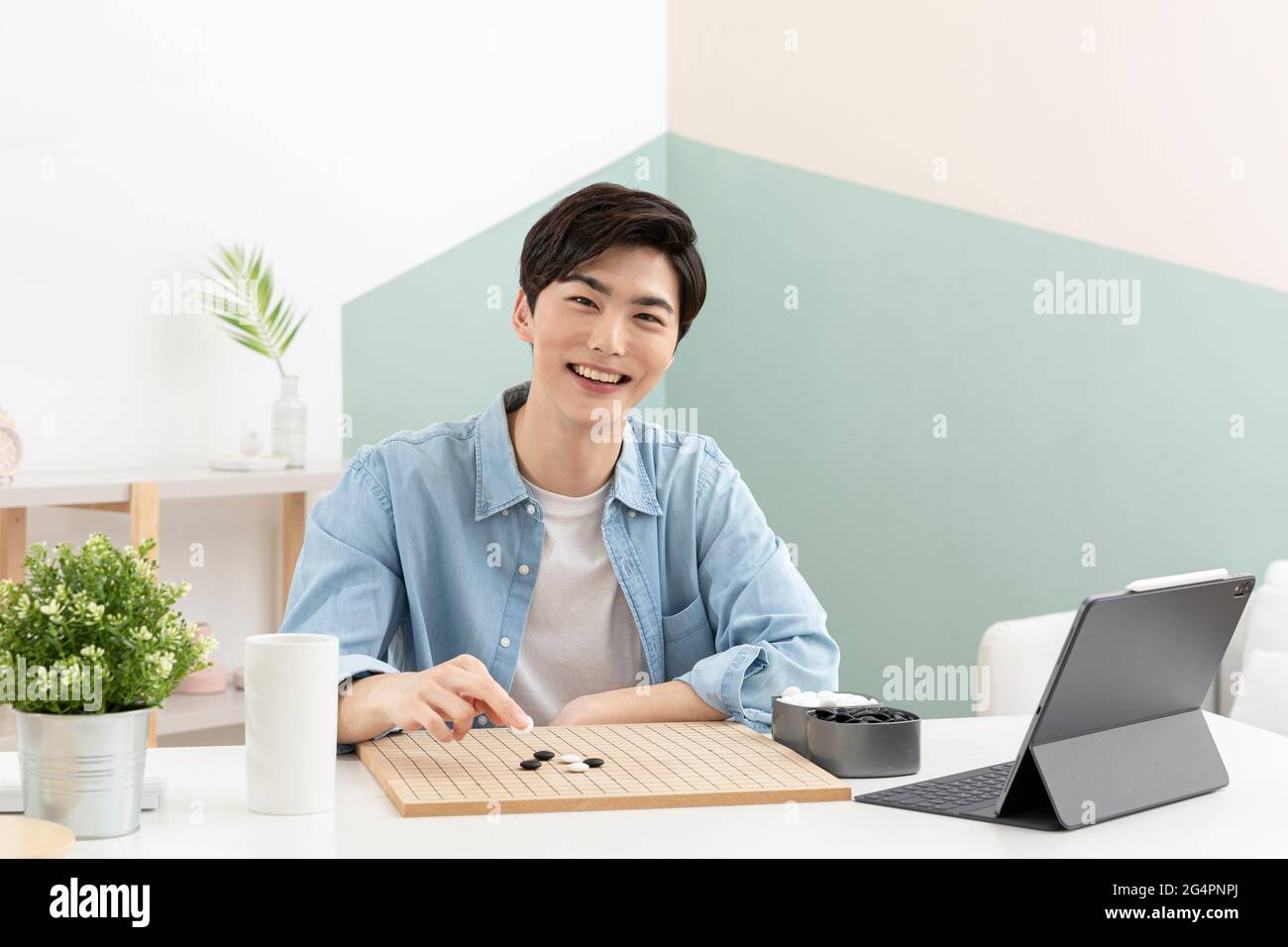 Asian young man learning chess through online class using tablet device ...