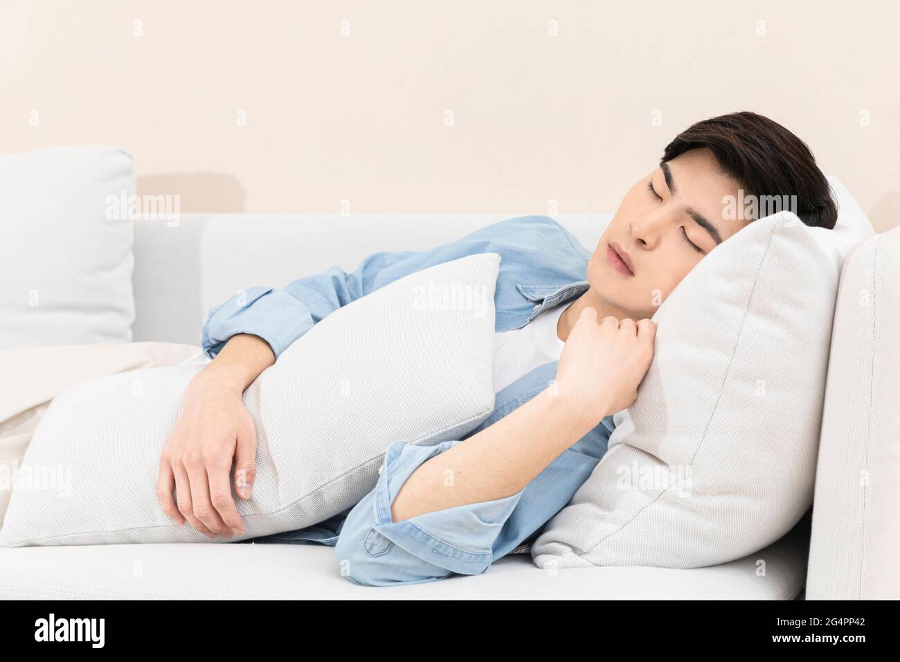 young Asian man sleeping in sofa Stock Photo - Alamy