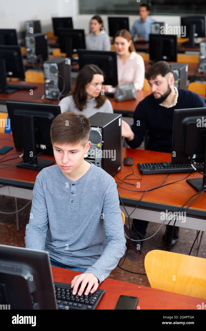 Group of people of different ages learning to use computers in ...