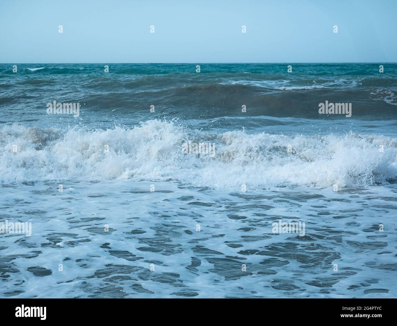 Waves of the Sea Reaching the Shore with Lots of Foam in a Cloudy and ...