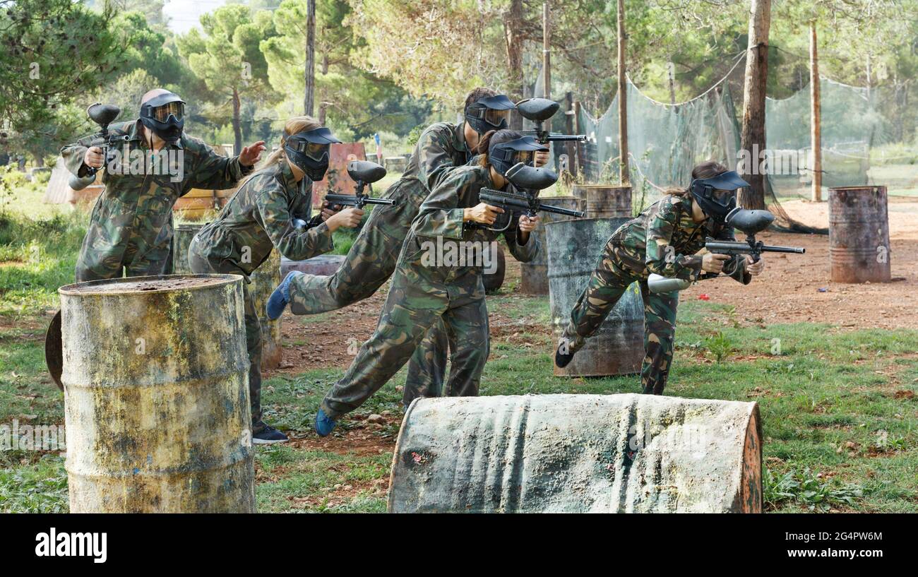 Paintball team running with marker guns Stock Photo - Alamy
