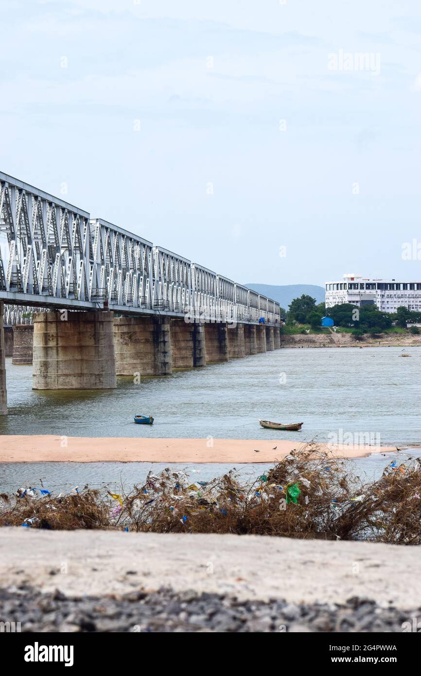Pair of small boats on a navigation channel with a large bridge behind ...