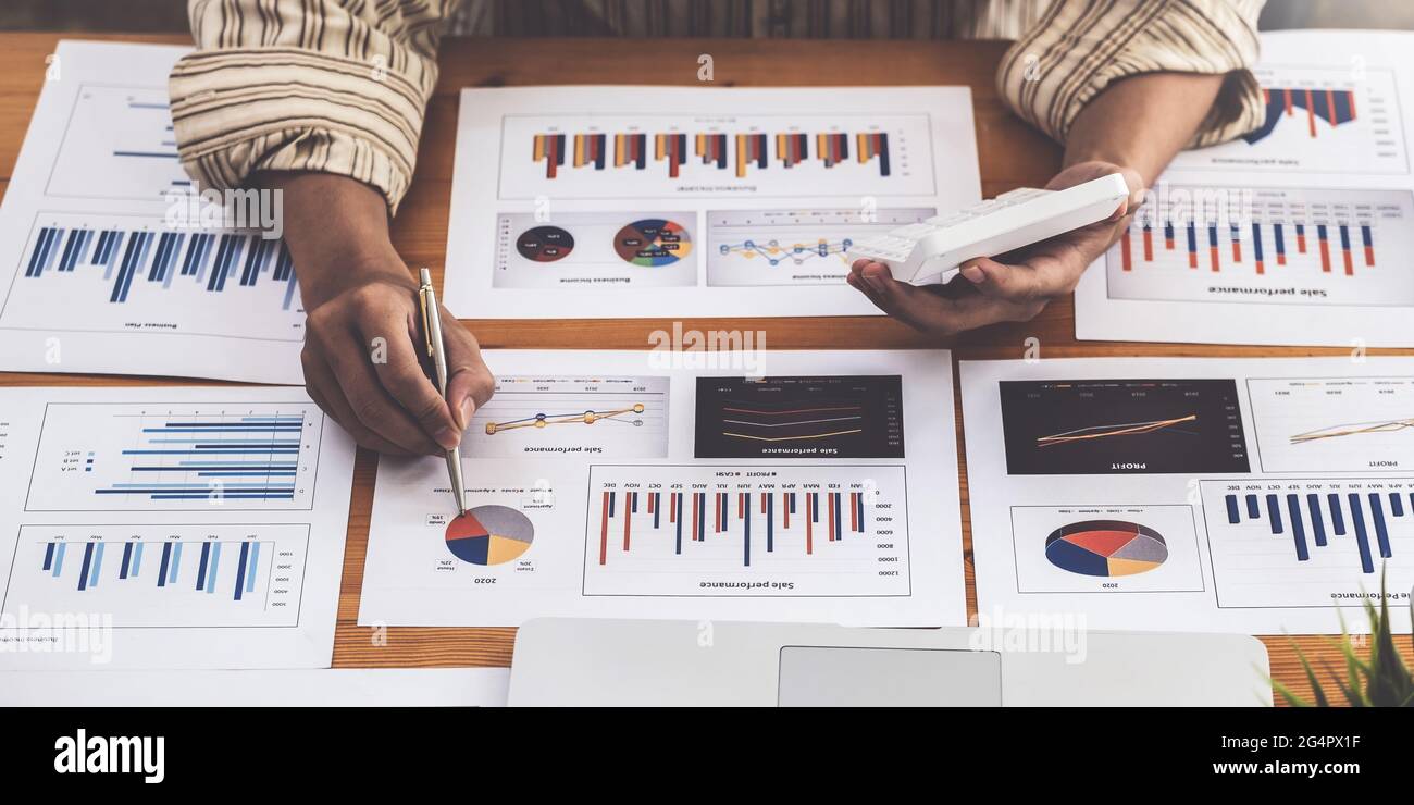 A businessman examines a financial report in paperwork, data from the ...