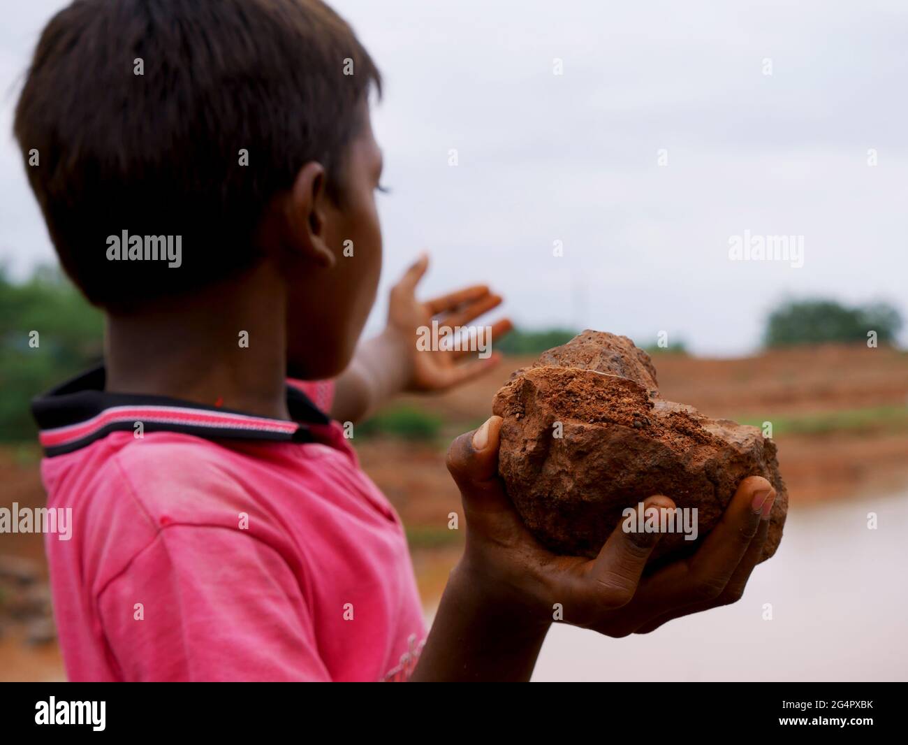 Indian village boy throwing stone on river, Stone closeup on hand kids ...