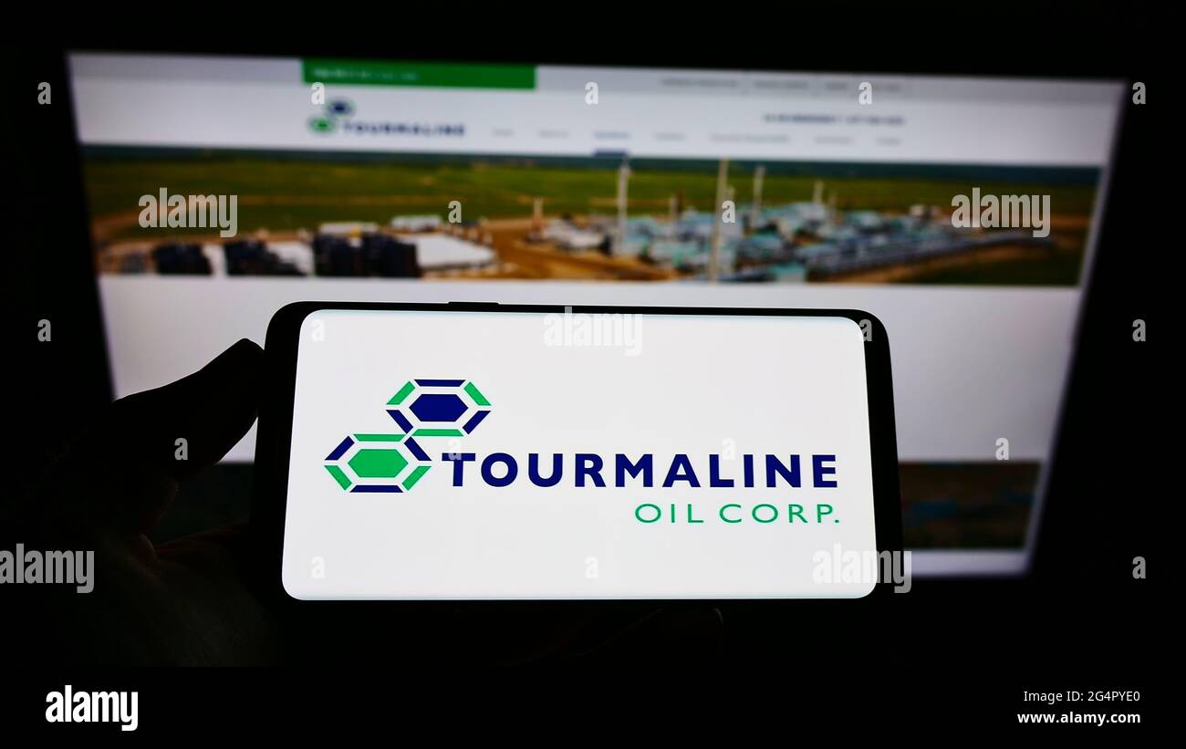 Person holding mobile phone with logo of Canadian energy company ...