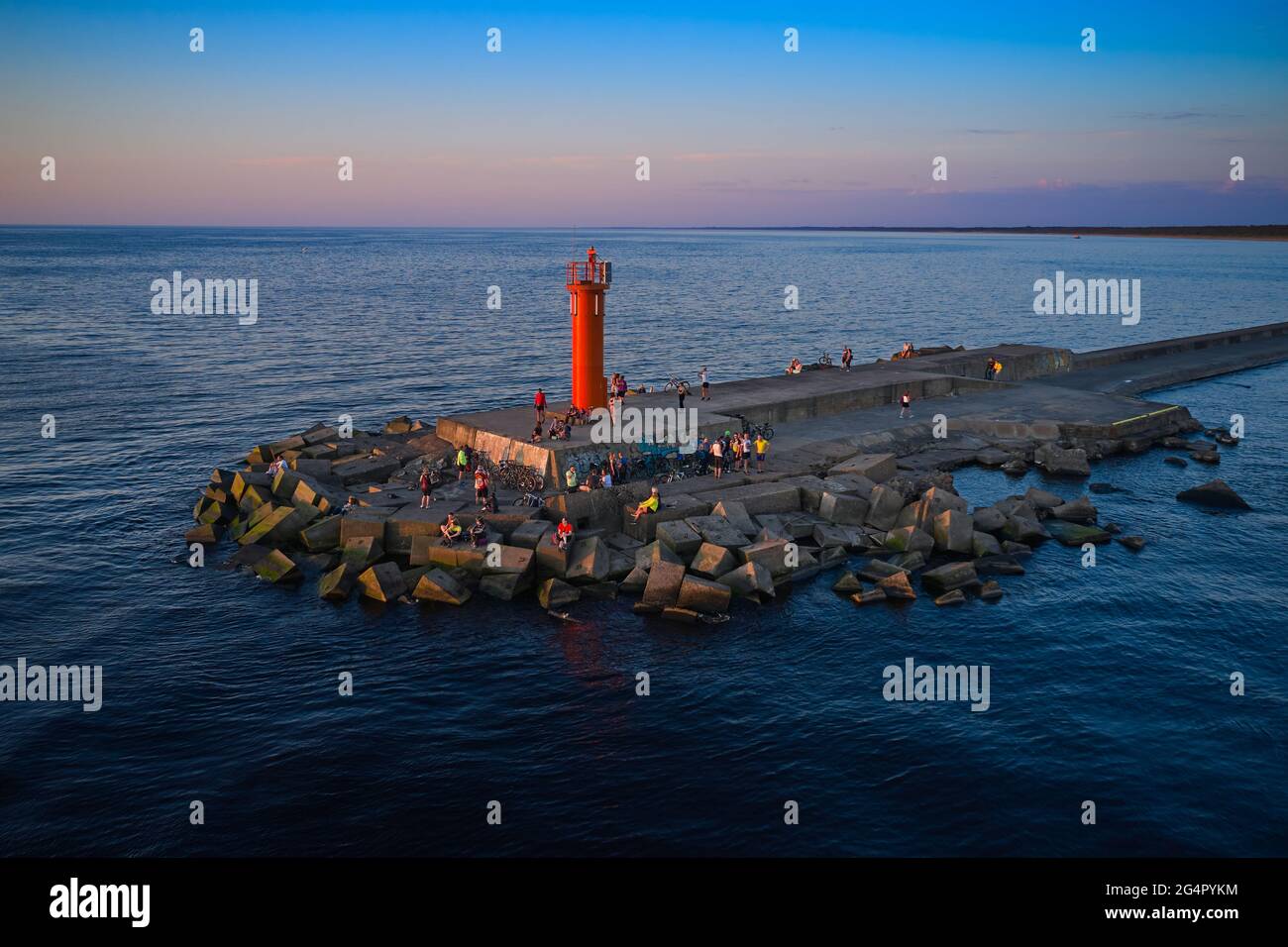 Amazing sunset sky and long stone pier with lighthouse Stock Photo - Alamy