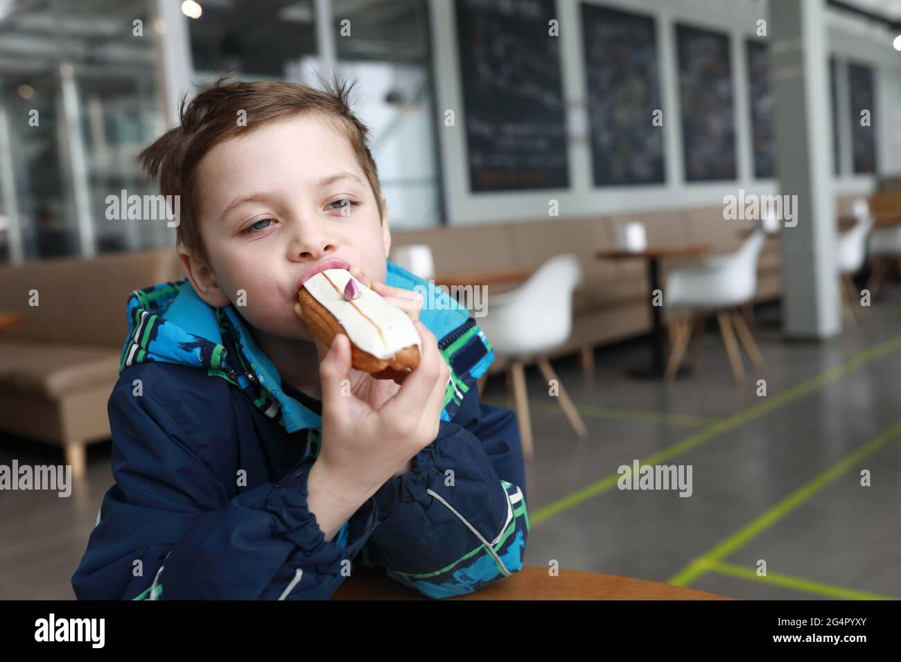 Portrait of child eating Eclair in restaurant Stock Photo - Alamy