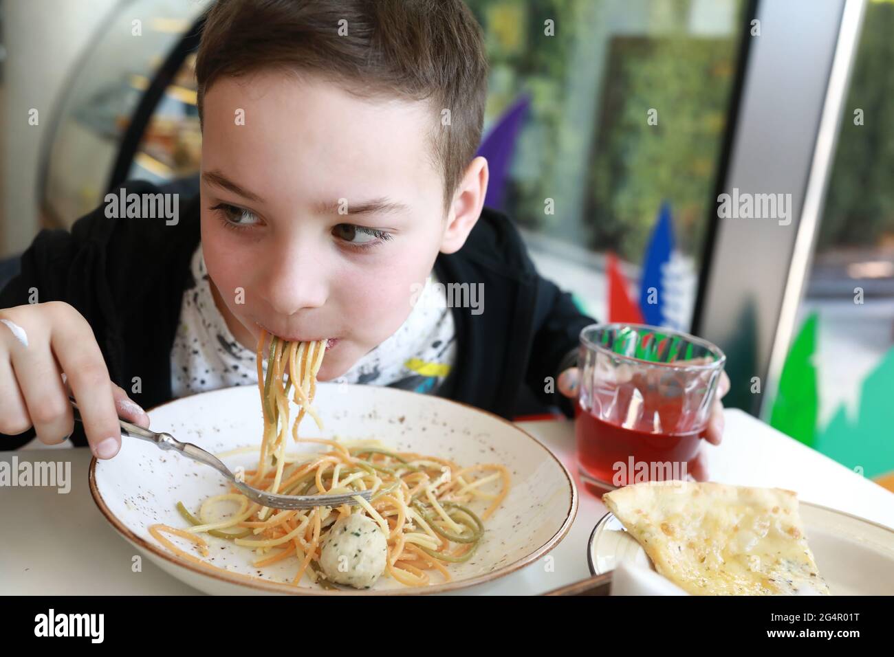 Kid eating spaghetti with chicken meatballs in restaurant Stock Photo ...