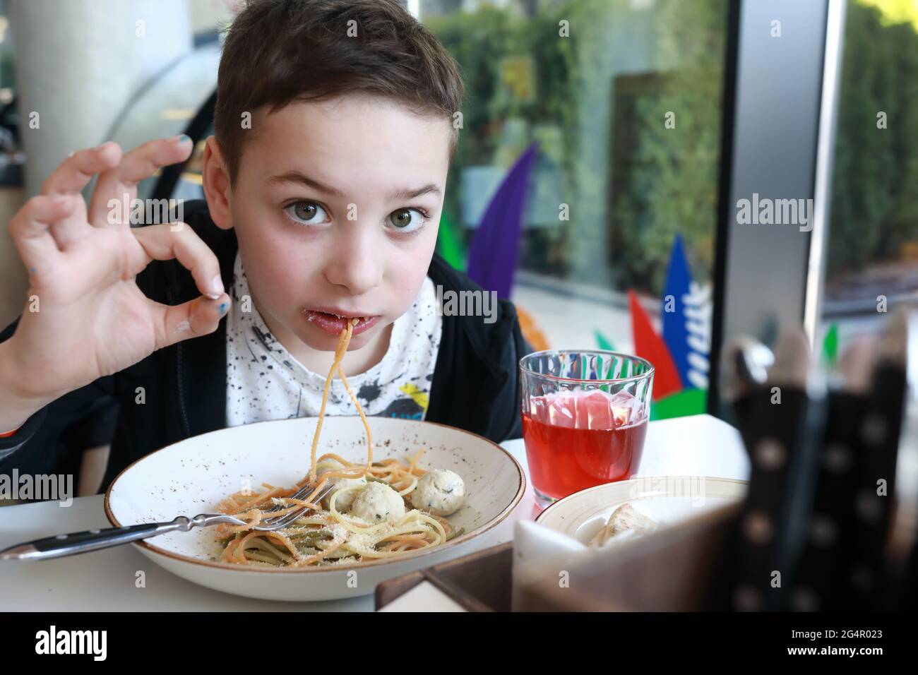 Child has spaghetti with chicken meatballs in restaurant Stock Photo ...