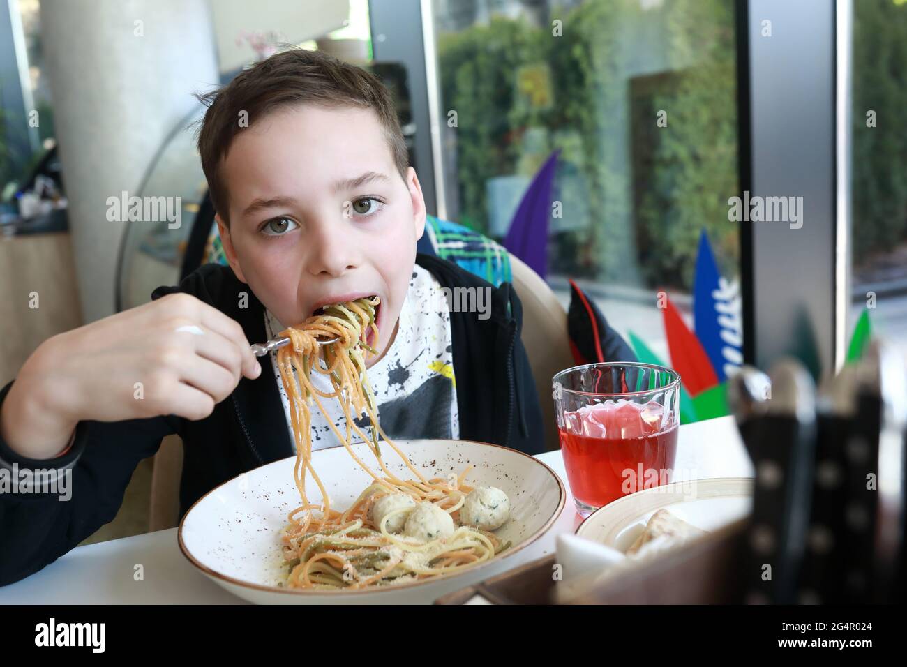 Child eating spaghetti with chicken meatballs in restaurant Stock Photo ...