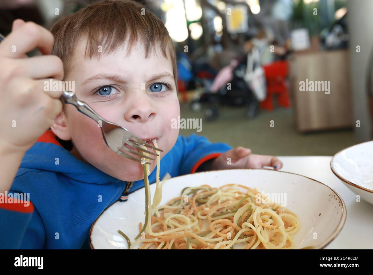 Hungry boy eating Spaghetti in a restaurant Stock Photo - Alamy