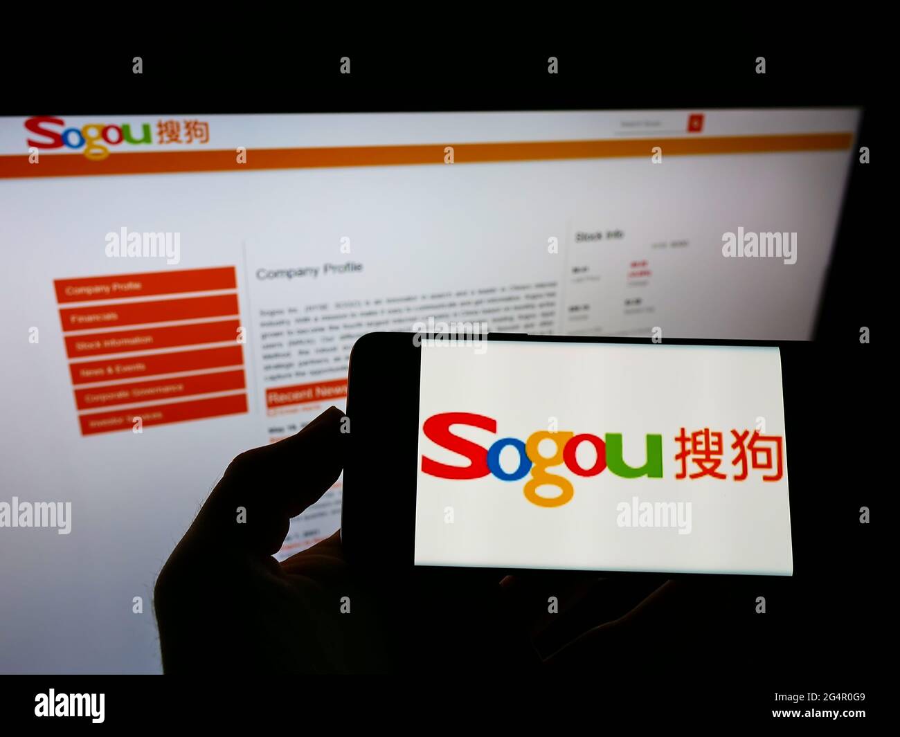 Person holding mobile phone with logo of Chinese technology company ...