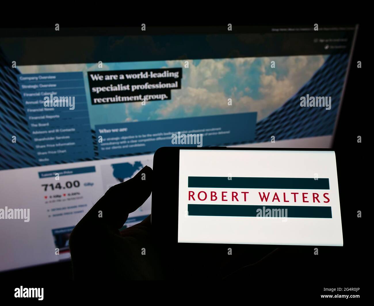Person holding cellphone with logo of British recruitment company Robert Walters plc on screen ...
