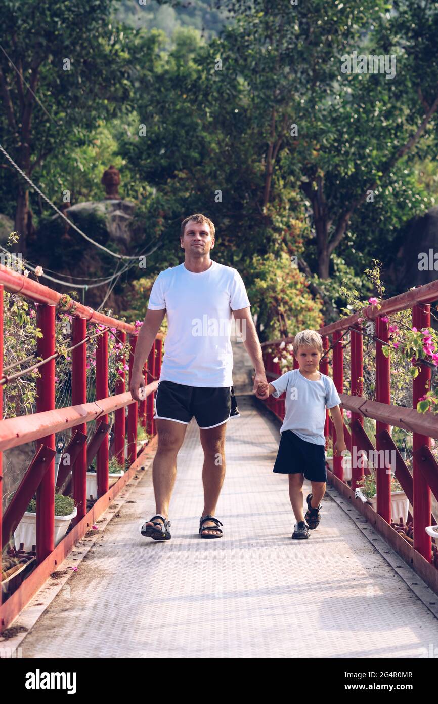 Dad Son walk spend time together explore new. Look at camera. Go across ...
